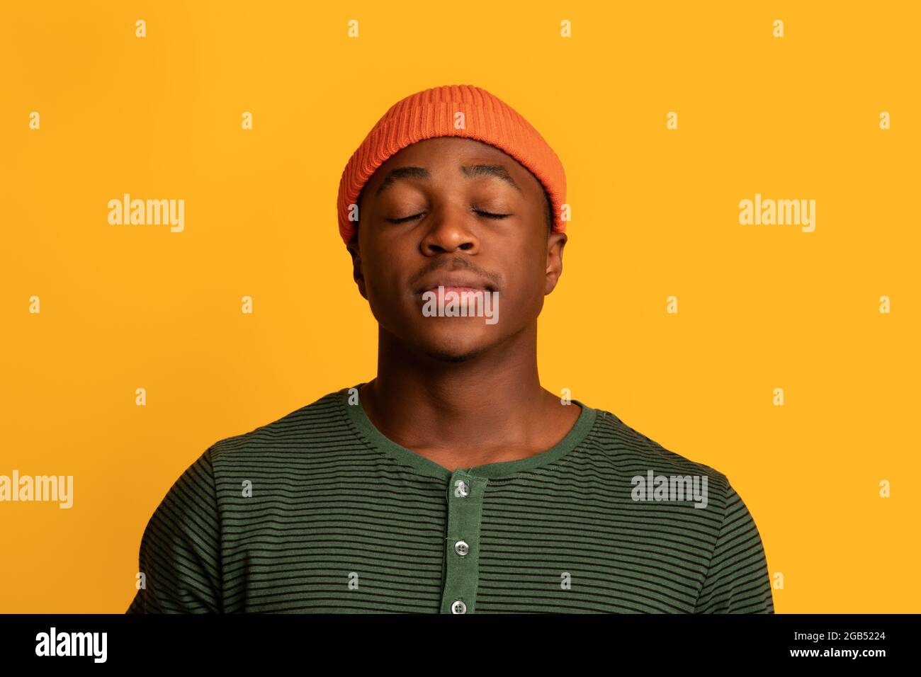 Portrait Of Calm Black Man Standing With Closed Eyes On Yellow ...