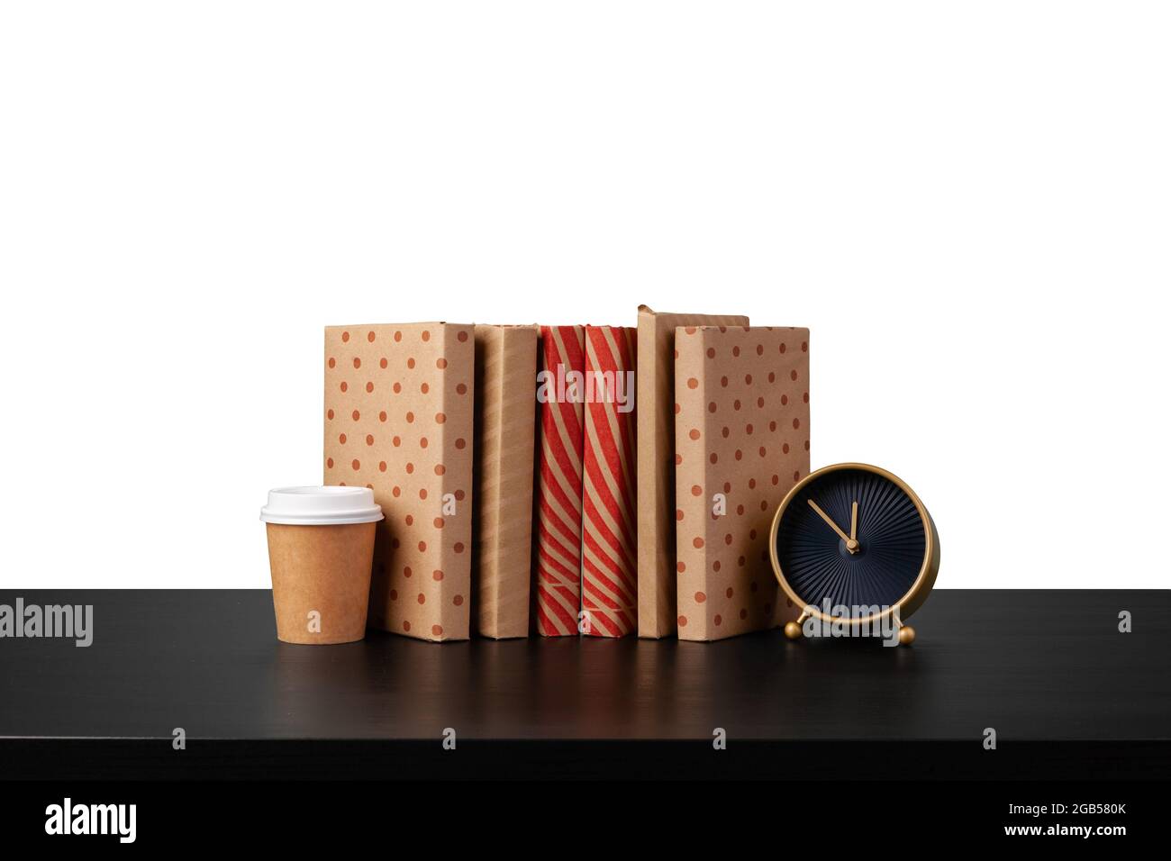 Alarm clock, stack of books and cup on tabletop against white ...
