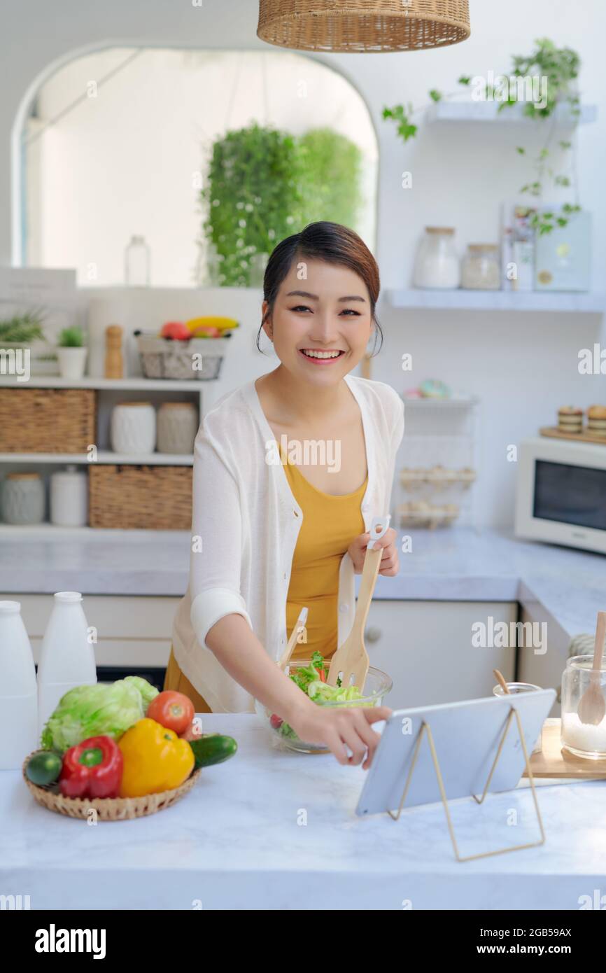 Woman cooking according the tutorial of online virtual master class ...