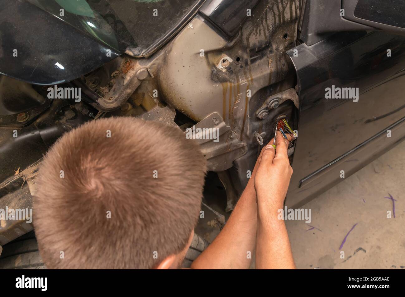 Specialist in repairing the electrical wiring of a car solves a problem ...