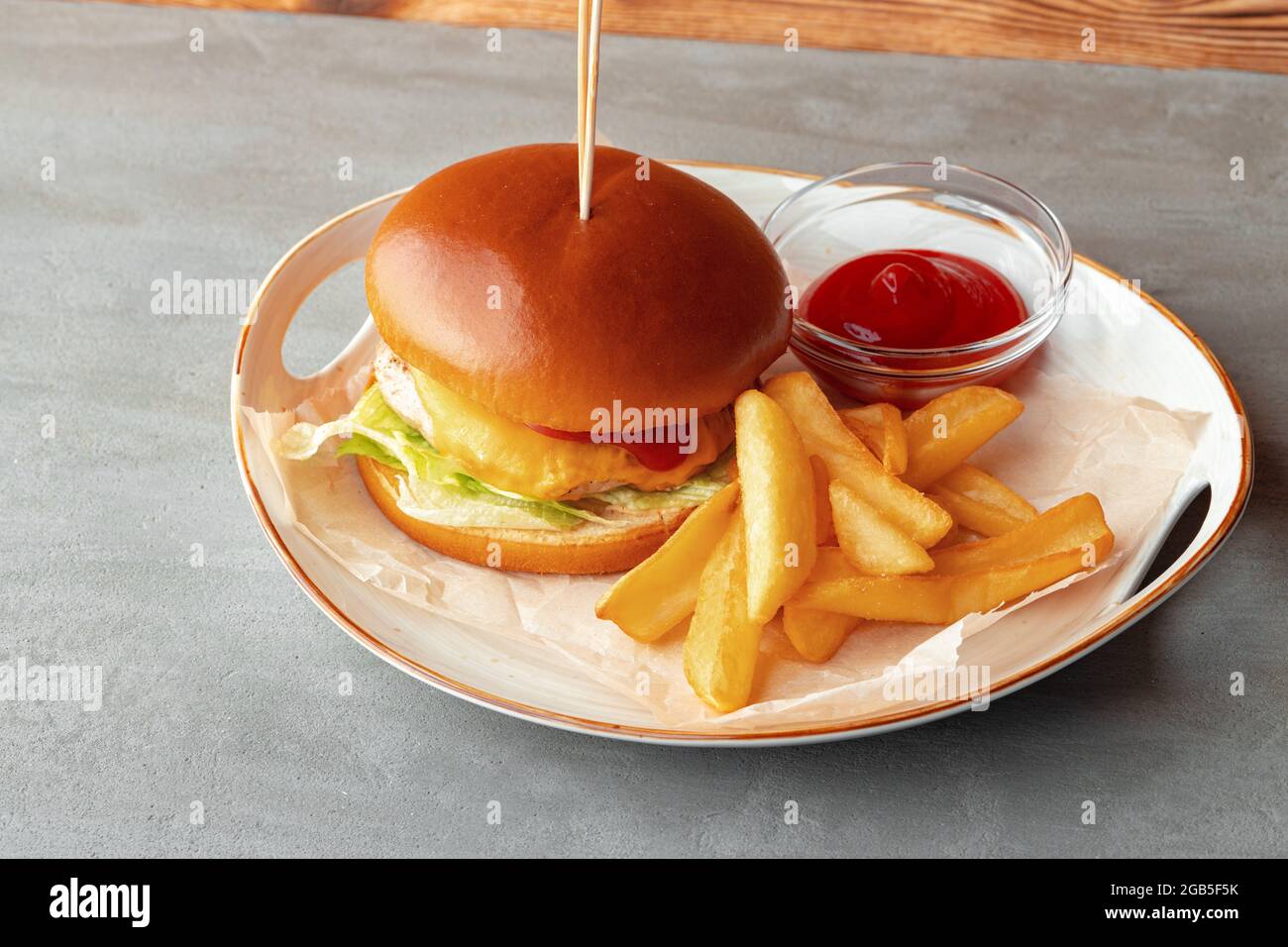 Fresh burger and potato wedges on gray wooden background Stock Photo ...