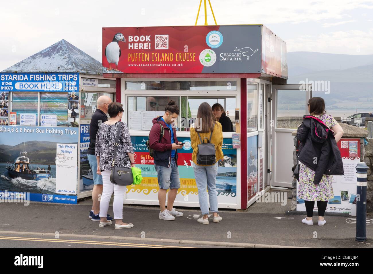 Staycation UK; people at the pier kiosk, Beaumaris, Anglesey Wales UK ...