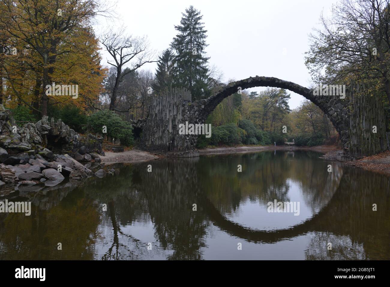 Mesmerizing view of a semicircle bridge over the lake with its ...