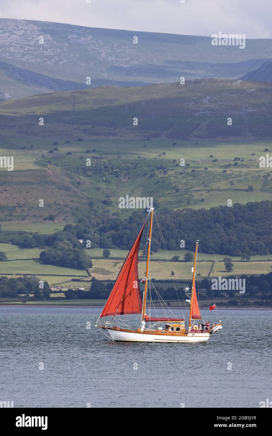 Menai Strait, Wales landscape; a ketch sailboat sailing along the Menai ...