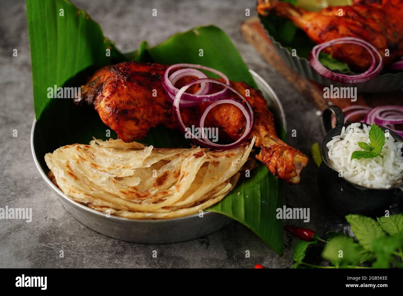 Homemade Tandoori chicken leg pieces served in a plate with roti ...