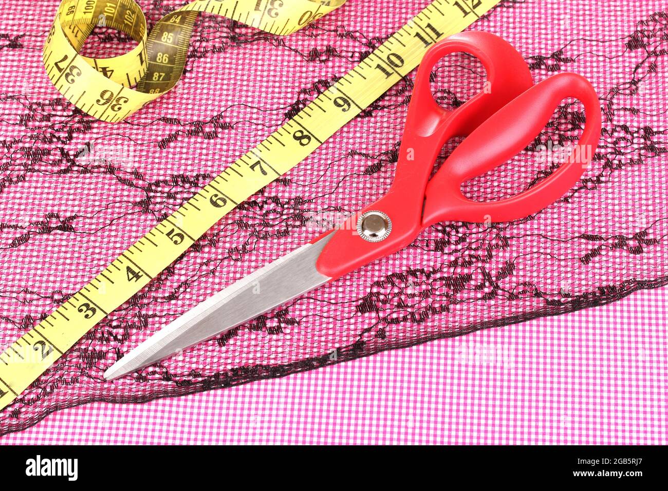 Scissors, measuring tape and pattern on fabric isolated on white Stock ...
