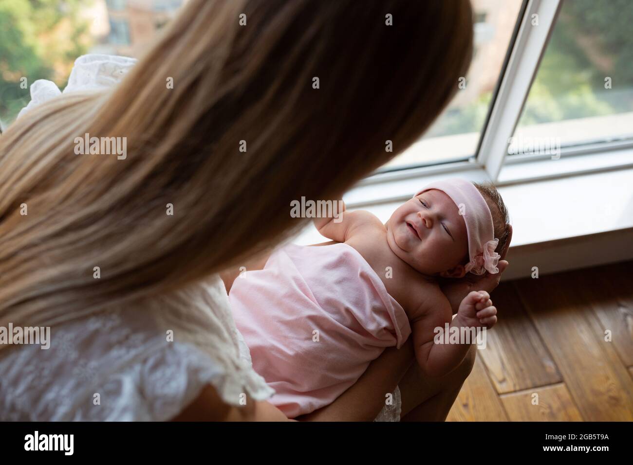 Portrait of young Caucasian mother holds hug little newborn baby two ...