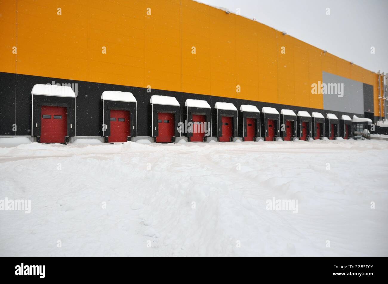 The empty loading area of a large warehouse is covered with snow in ...