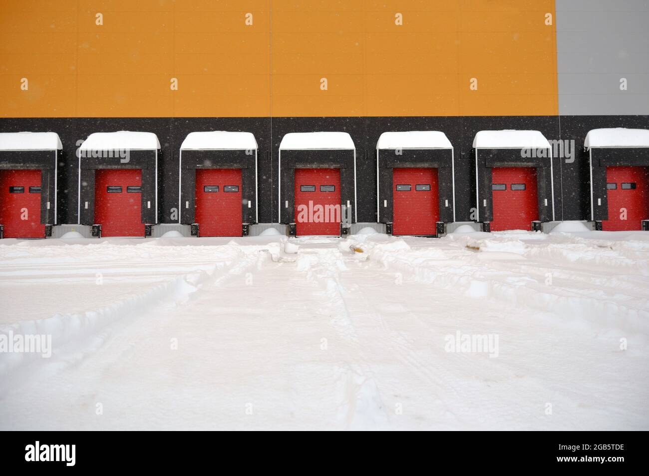 The empty loading area of a large warehouse is covered with snow in ...