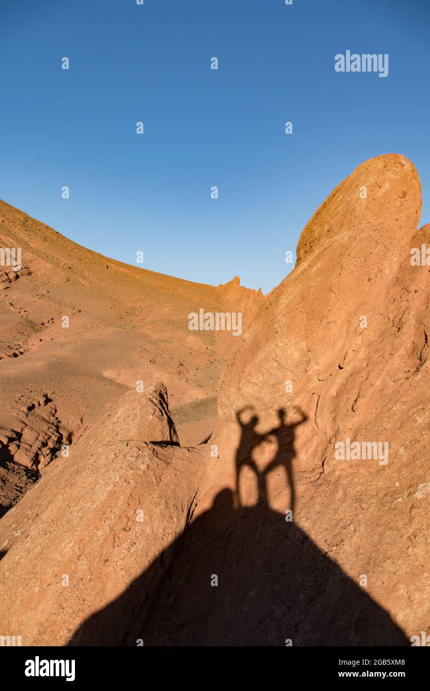 Shadows of cheerful tourists in the background of sandstone rocks in ...