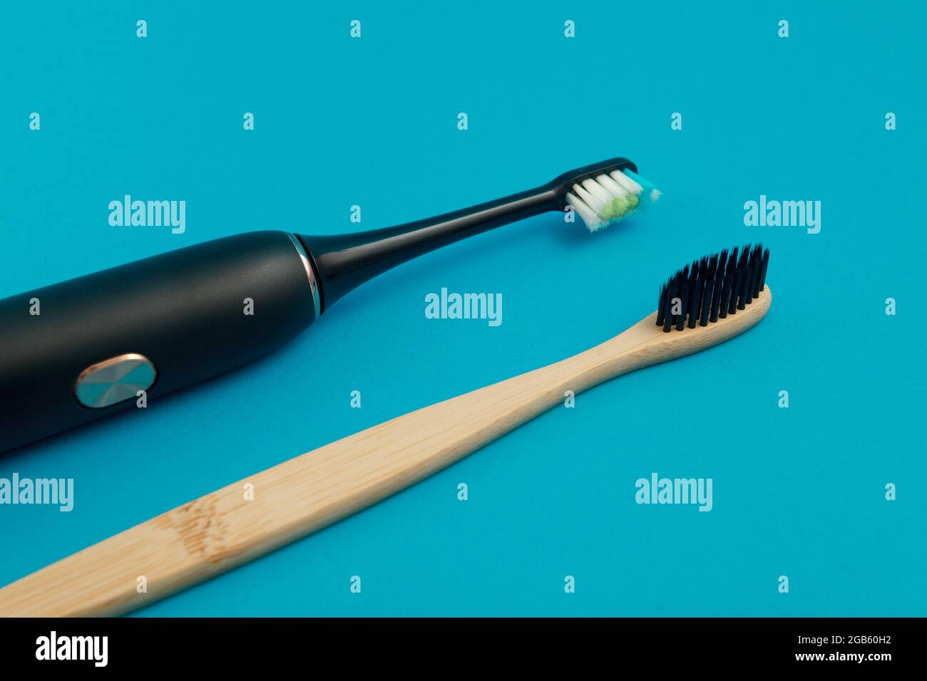 Electric and wooden toothbrush on blue background Stock Photo - Alamy