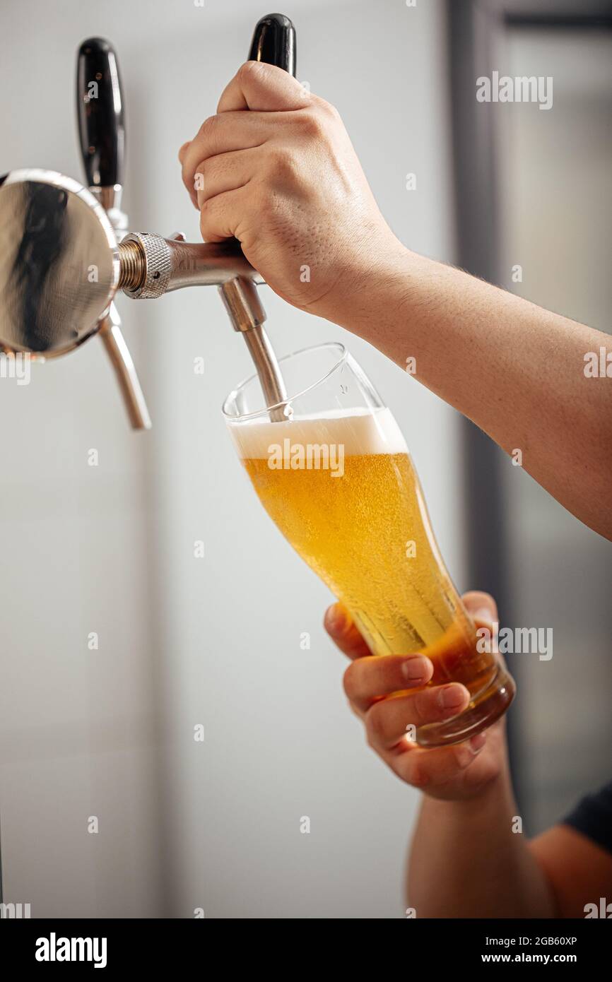 Hands pouring draught beer into a glass Stock Photo - Alamy