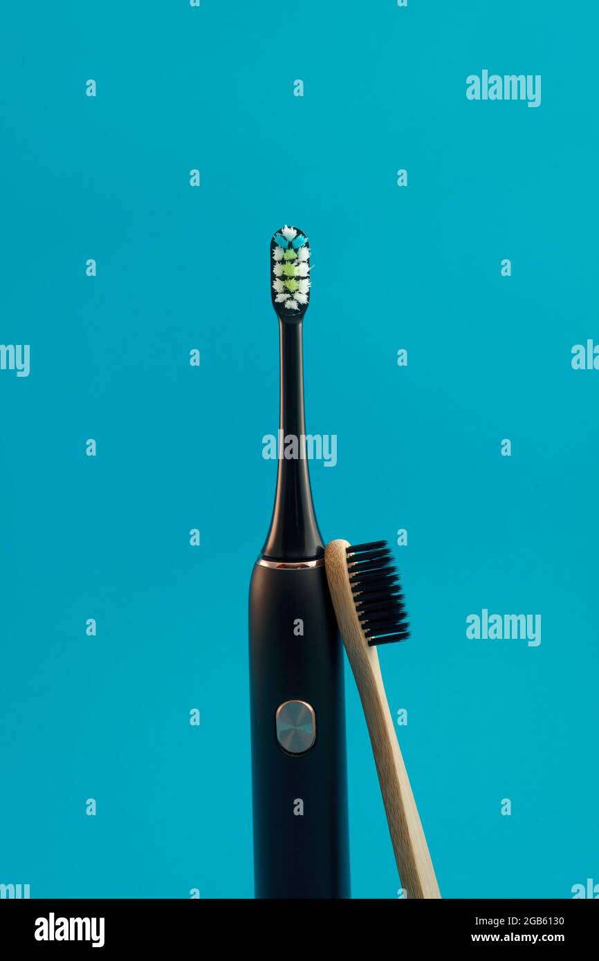 Electric and wooden toothbrush on blue background Stock Photo - Alamy