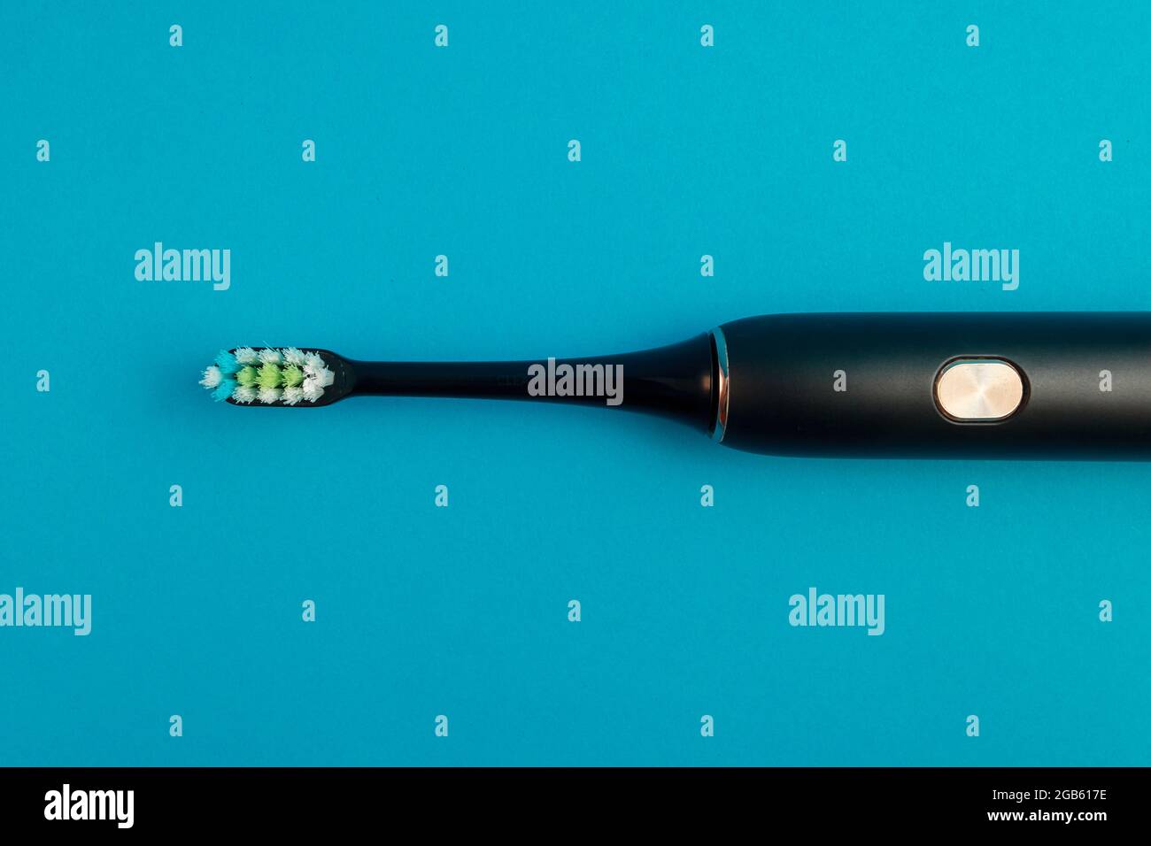 Electric toothbrush on blue background Stock Photo - Alamy