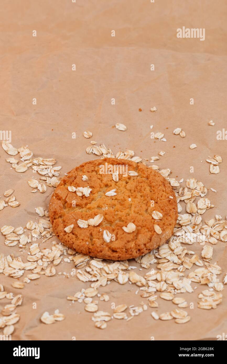 oatmeal cookies and scattered oatmeal on crumpled paper background ...