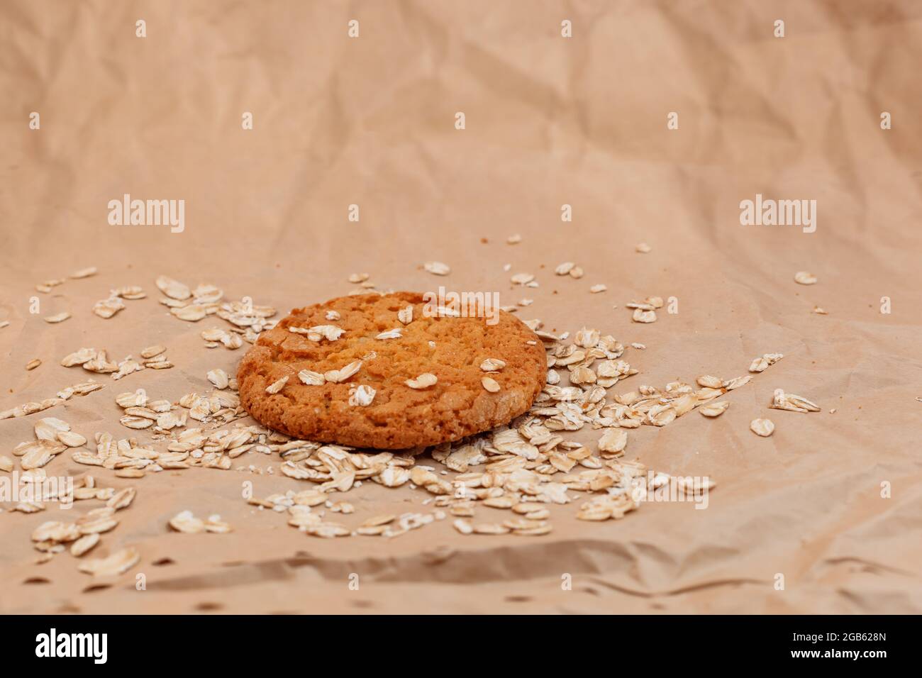 oatmeal cookies and scattered oatmeal on crumpled paper background ...