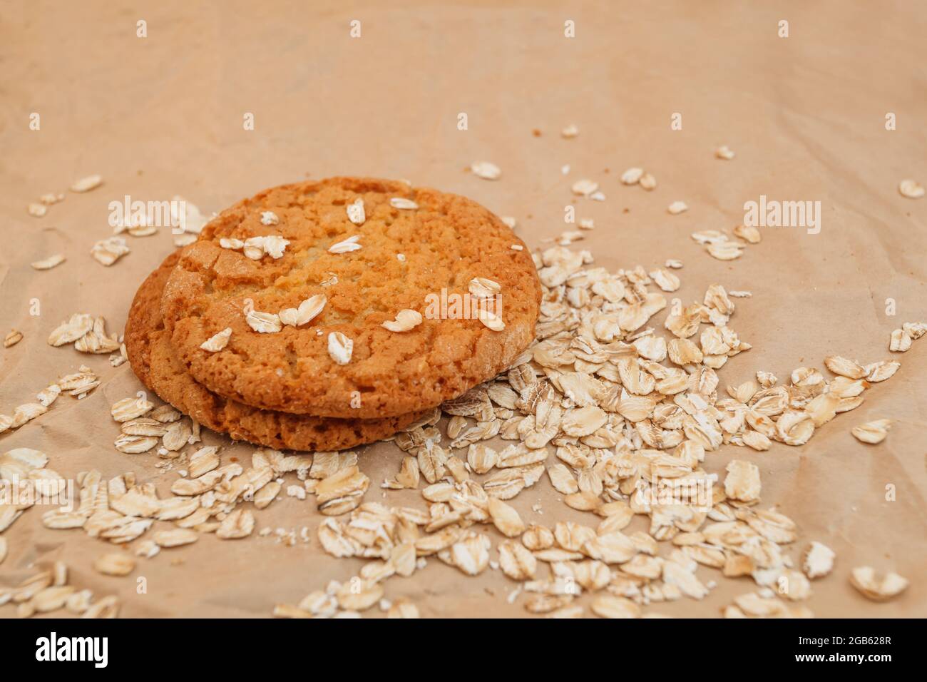 oatmeal cookies and scattered oatmeal on crumpled paper background ...