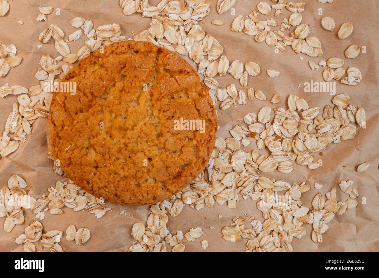 oatmeal cookies and scattered oatmeal on crumpled paper background ...