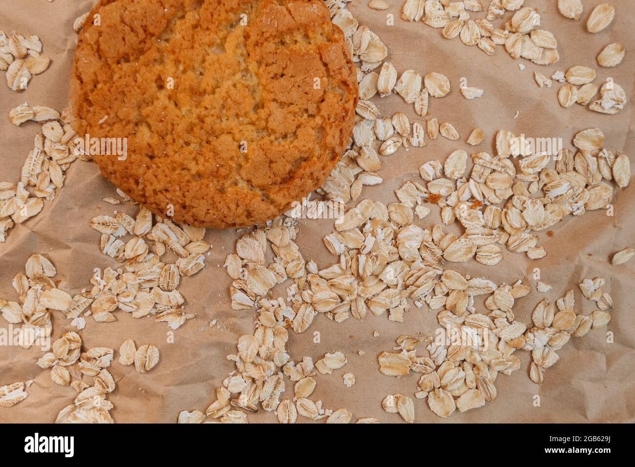 oatmeal cookies and scattered oatmeal on crumpled paper background ...