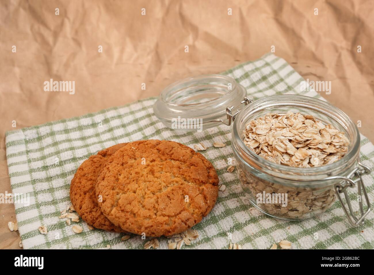 oatmeal cookies and scattered oatmeal on crumpled paper background ...