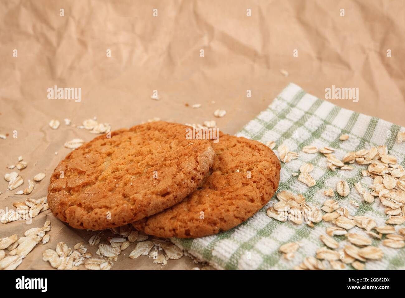 oatmeal cookies and scattered oatmeal on crumpled paper background ...