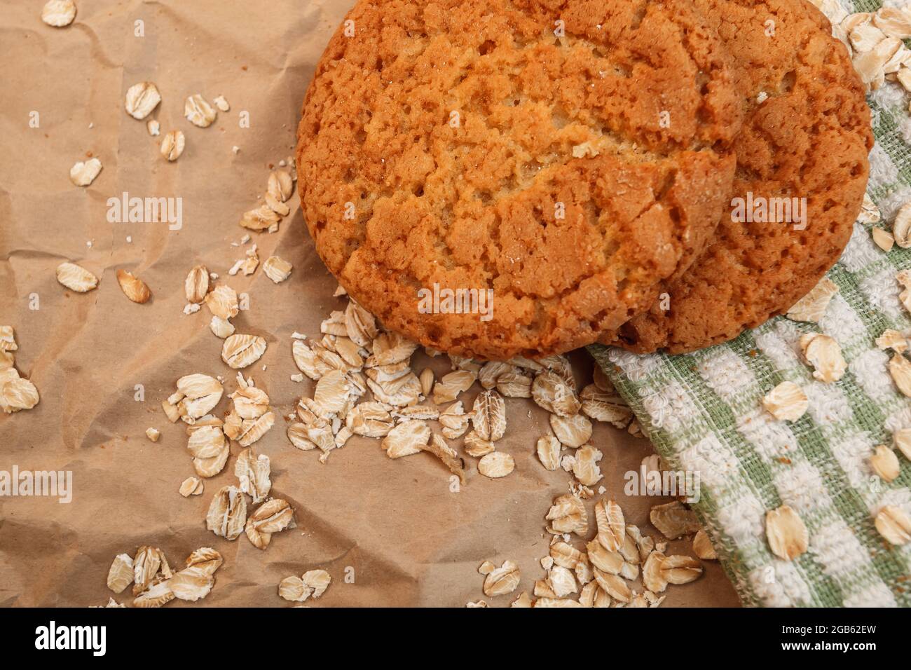 oatmeal cookies and scattered oatmeal on crumpled paper background ...