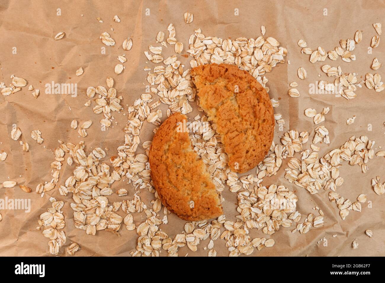 oatmeal cookies and scattered oatmeal on crumpled paper background ...