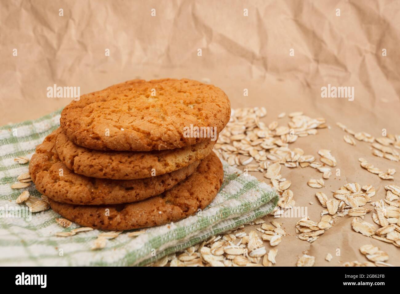 oatmeal cookies and scattered oatmeal on crumpled paper background ...