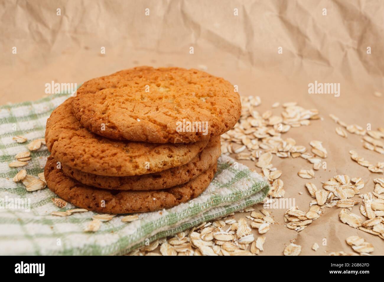 oatmeal cookies and scattered oatmeal on crumpled paper background ...