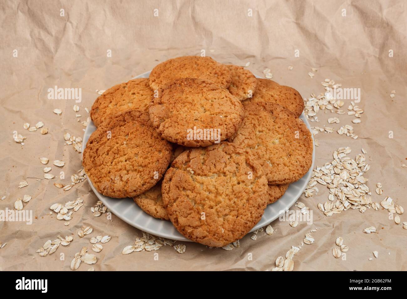 oatmeal cookies and scattered oatmeal on crumpled paper background ...