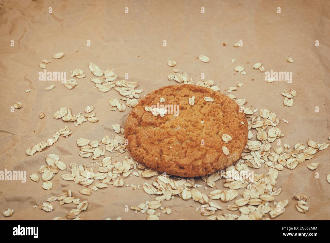 oatmeal cookies and scattered oatmeal on crumpled paper background ...