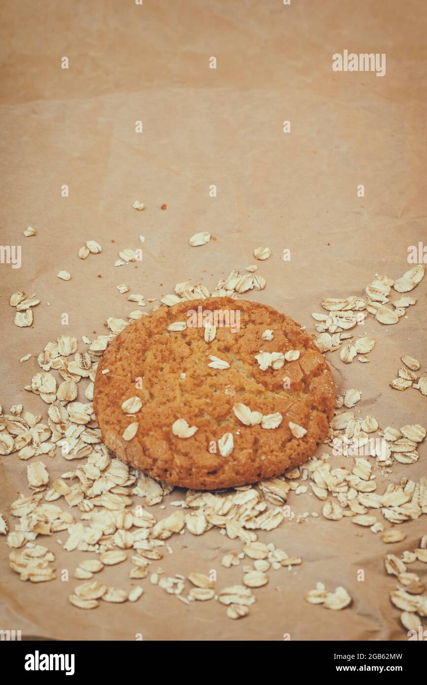 oatmeal cookies and scattered oatmeal on crumpled paper background ...