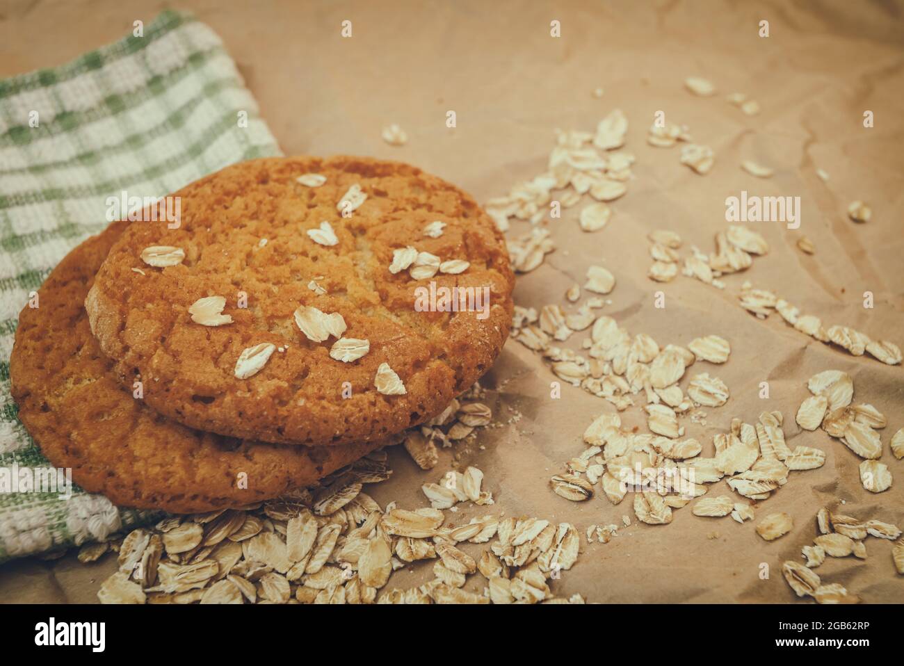 oatmeal cookies and scattered oatmeal on crumpled paper background ...