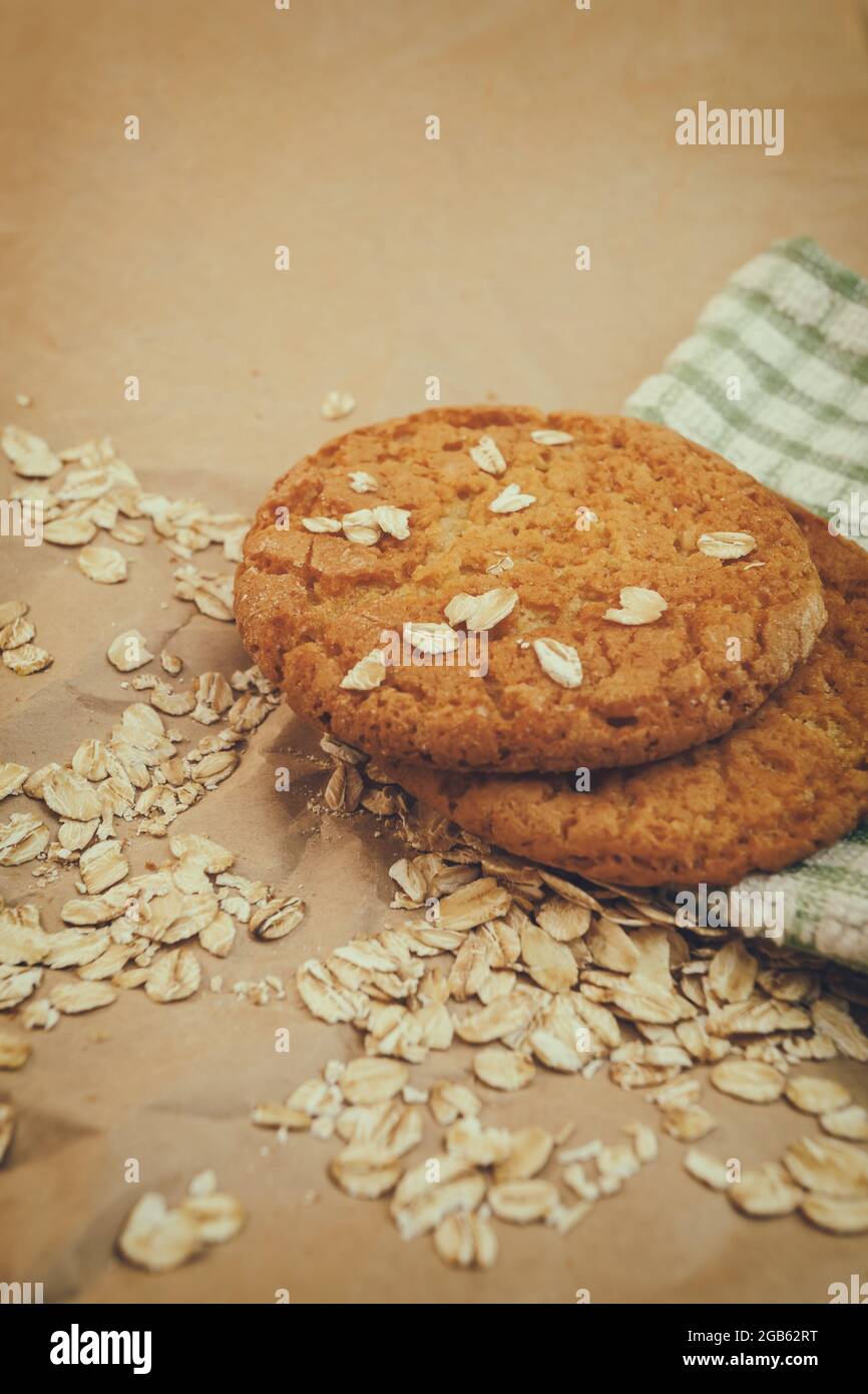 oatmeal cookies and scattered oatmeal on crumpled paper background ...