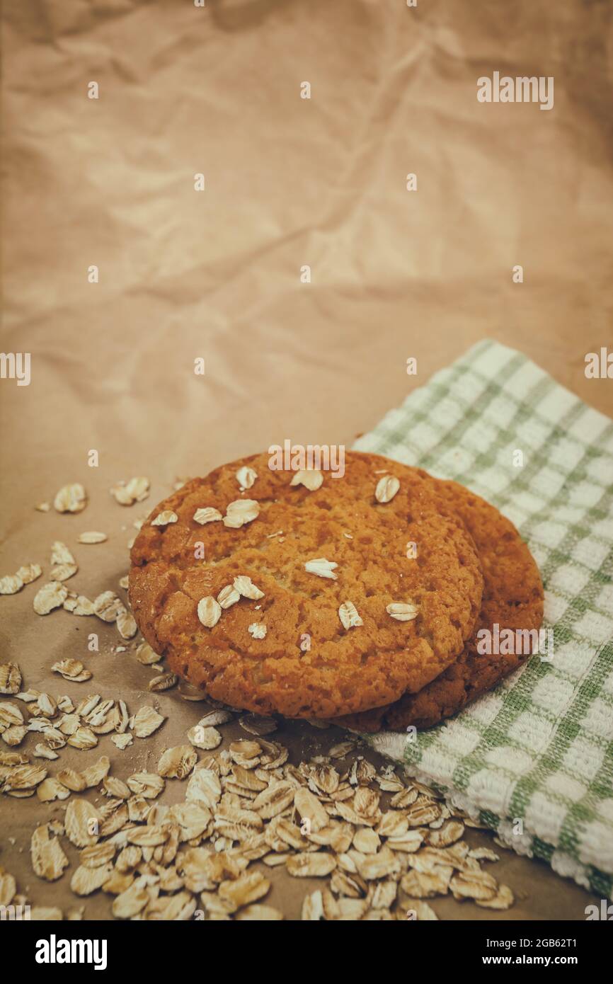 oatmeal cookies and scattered oatmeal on crumpled paper background ...