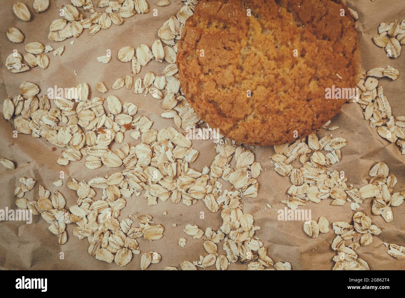 oatmeal cookies and scattered oatmeal on crumpled paper background ...