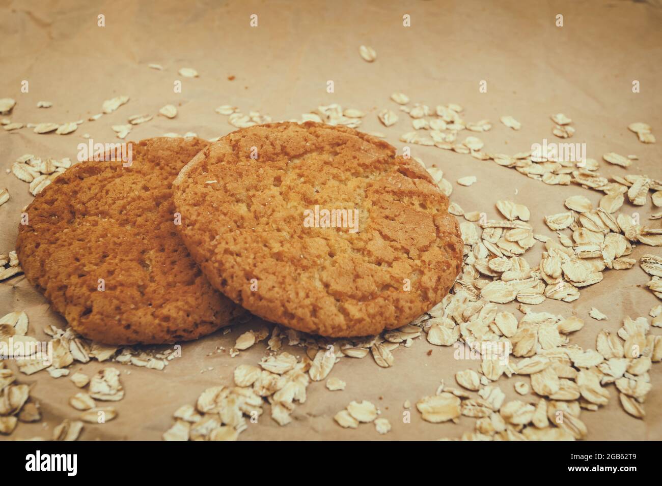 oatmeal cookies and scattered oatmeal on crumpled paper background ...