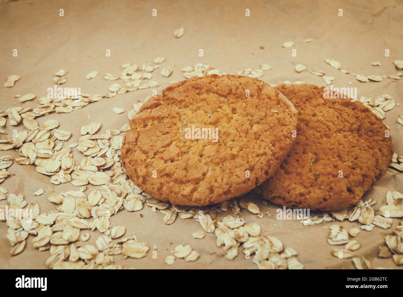 oatmeal cookies and scattered oatmeal on crumpled paper background ...