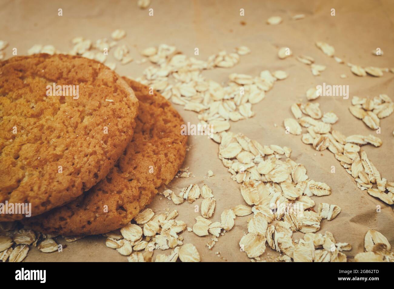 oatmeal cookies and scattered oatmeal on crumpled paper background ...