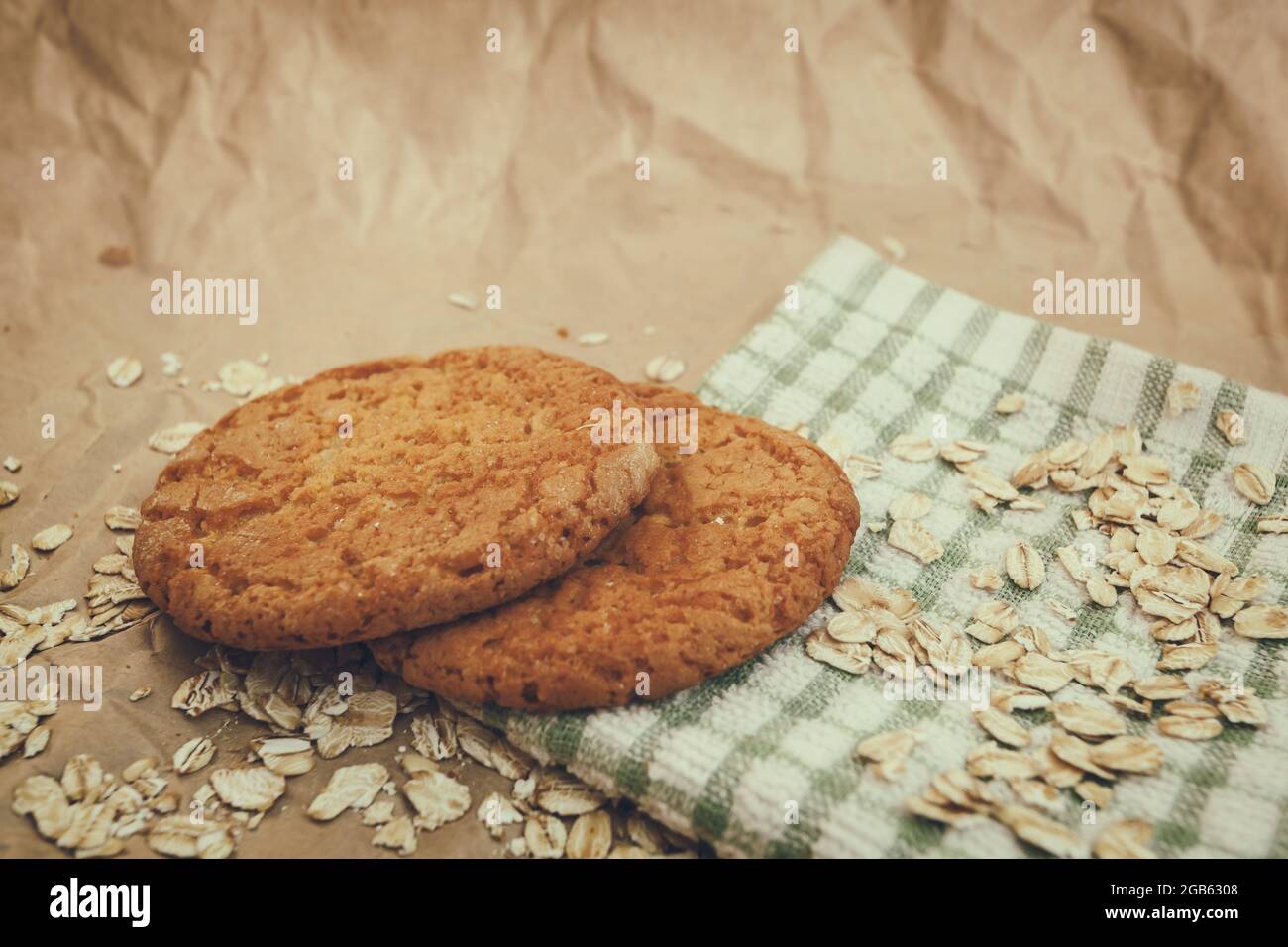 oatmeal cookies and scattered oatmeal on crumpled paper background ...
