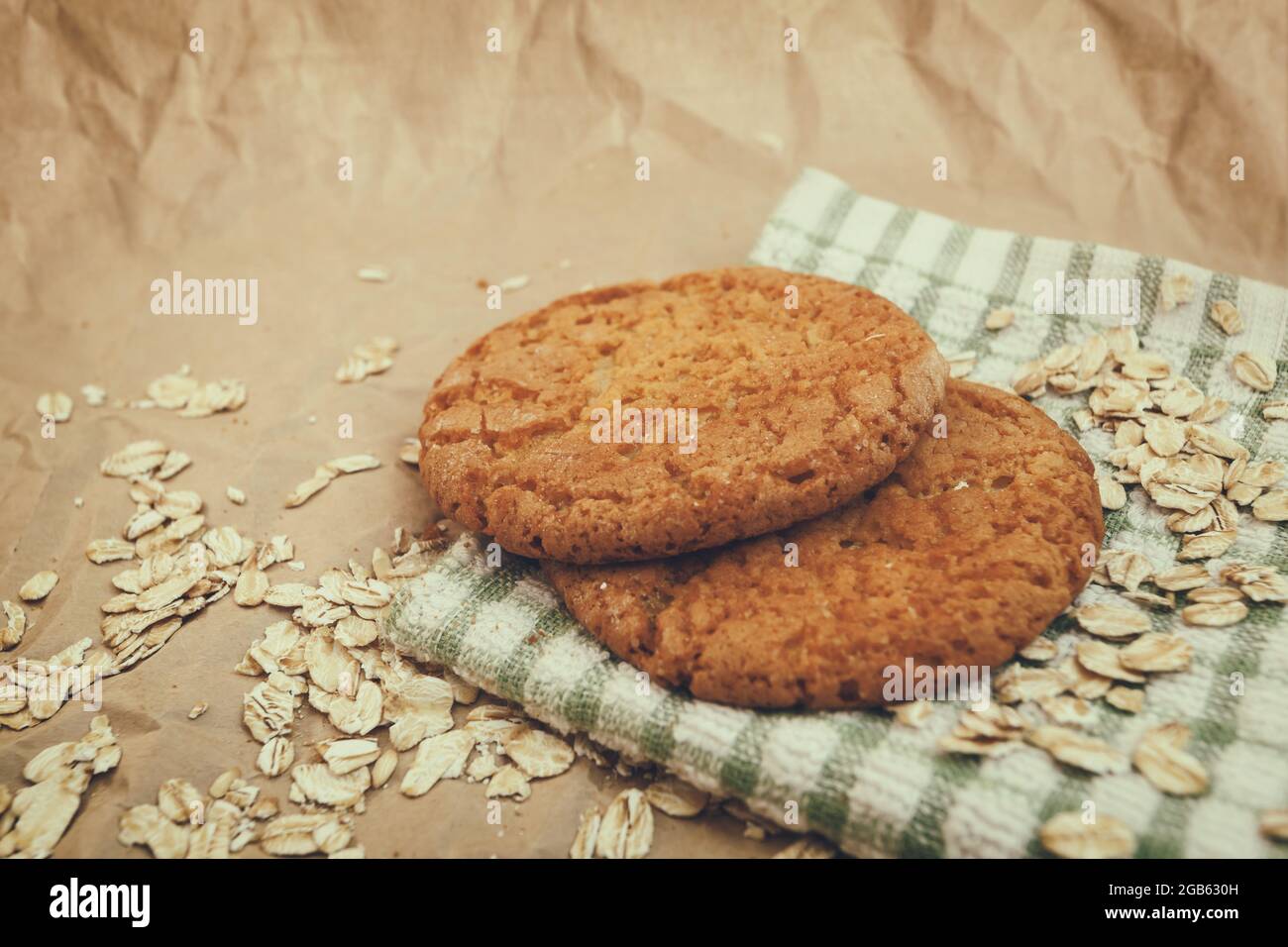 oatmeal cookies and scattered oatmeal on crumpled paper background ...