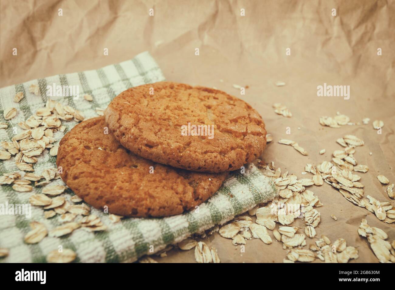 oatmeal cookies and scattered oatmeal on crumpled paper background ...