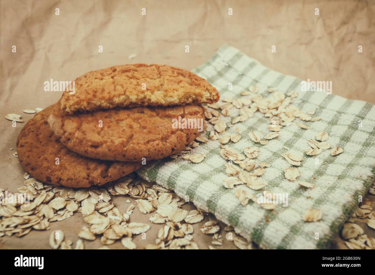 oatmeal cookies and scattered oatmeal on crumpled paper background ...