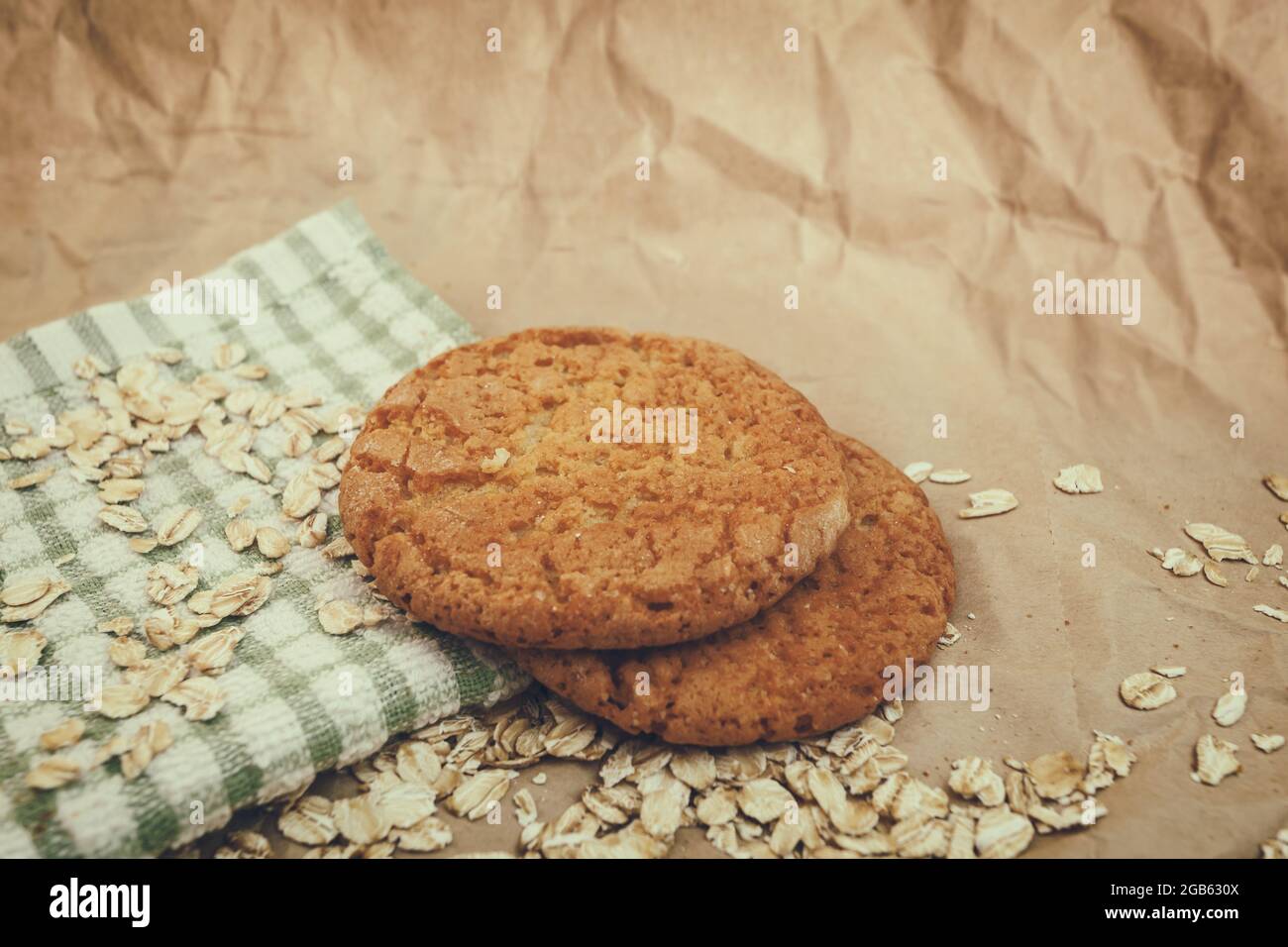 oatmeal cookies and scattered oatmeal on crumpled paper background ...