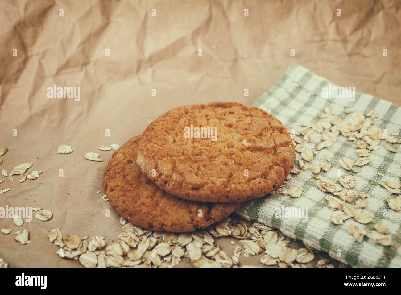 oatmeal cookies and scattered oatmeal on crumpled paper background ...