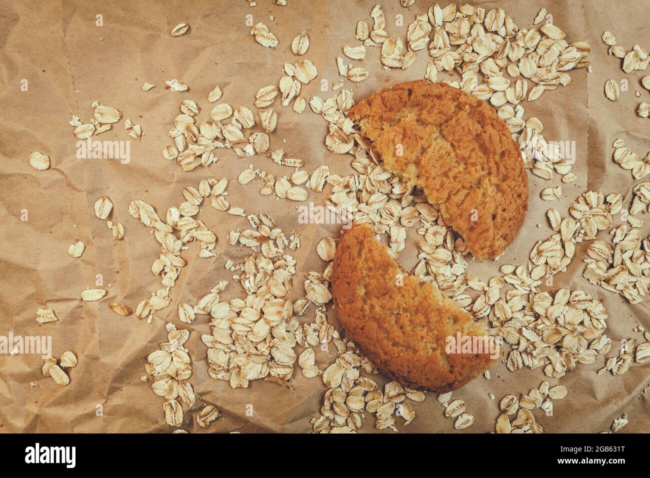 oatmeal cookies and scattered oatmeal on crumpled paper background ...