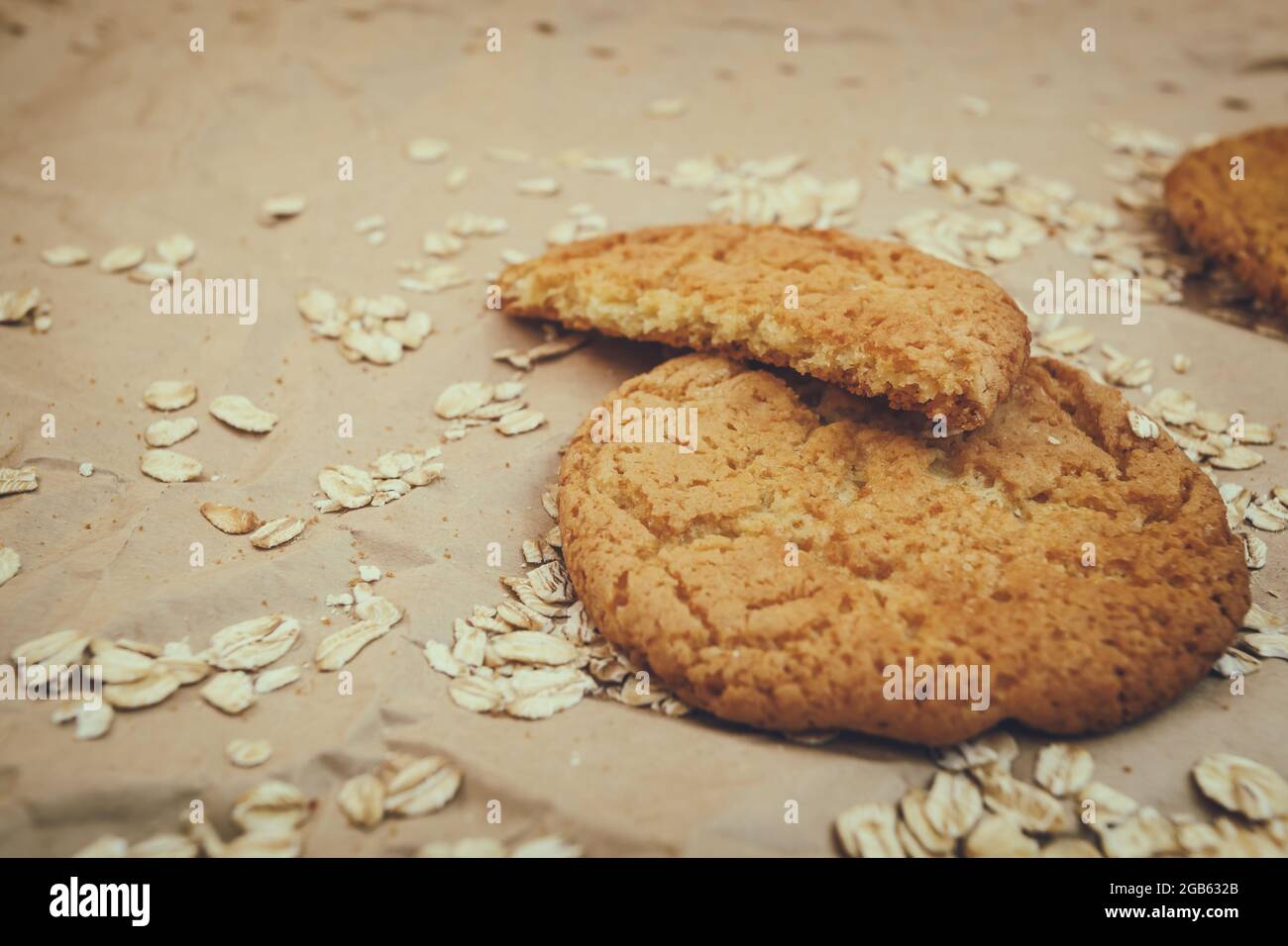 oatmeal cookies and scattered oatmeal on crumpled paper background ...