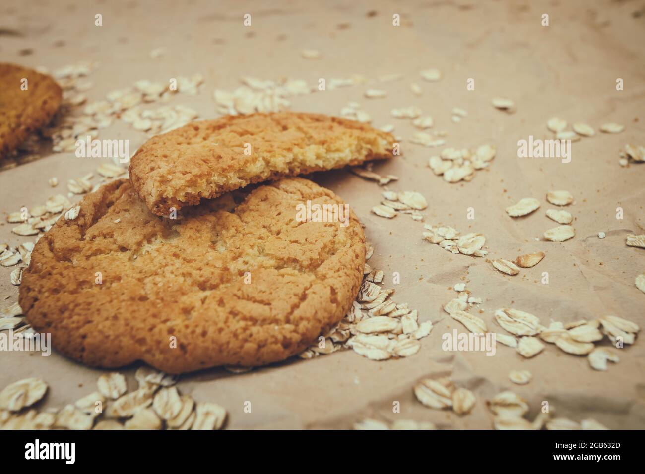 oatmeal cookies and scattered oatmeal on crumpled paper background ...