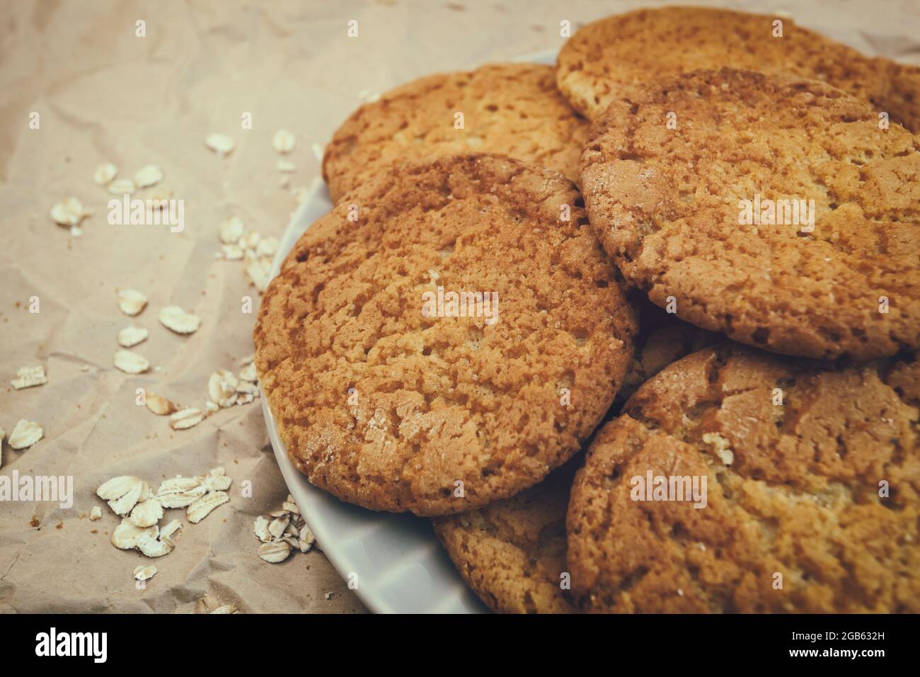 oatmeal cookies and scattered oatmeal on crumpled paper background ...