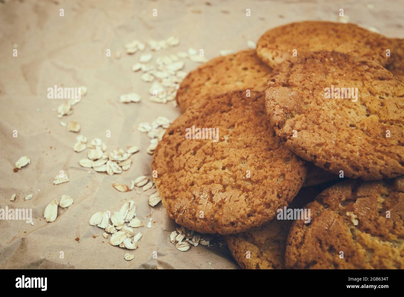 oatmeal cookies and scattered oatmeal on crumpled paper background ...